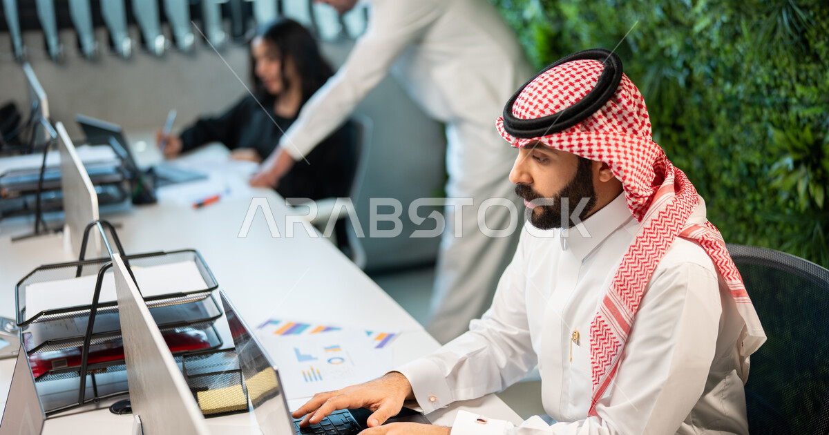 An Arab, Saudi, Gulf employee wearing the traditional Saudi dress and ...