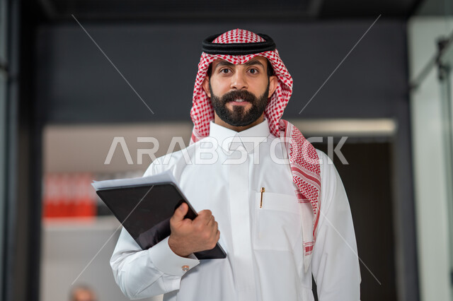 A Saudi Arabian Gulf employee wearing the traditional Saudi shemagh and ...