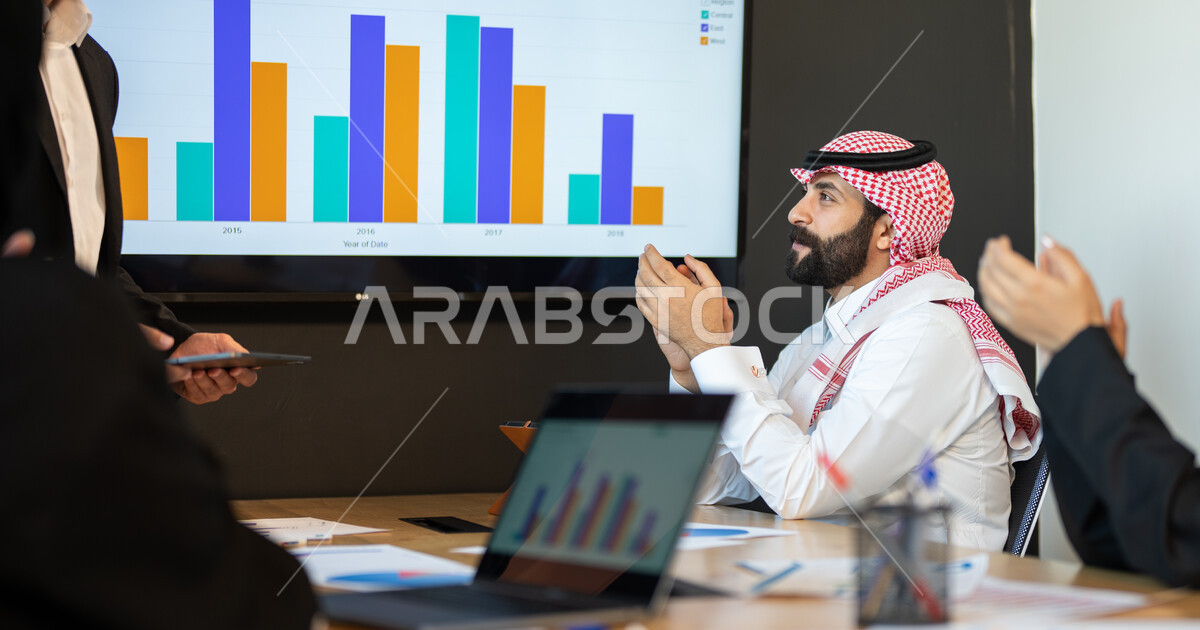 Unity and teamwork, an Arab Gulf Saudi work team holding a business ...