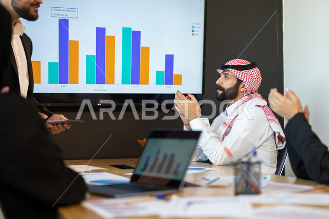 Unity and teamwork, an Arab Gulf Saudi work team holding a business ...