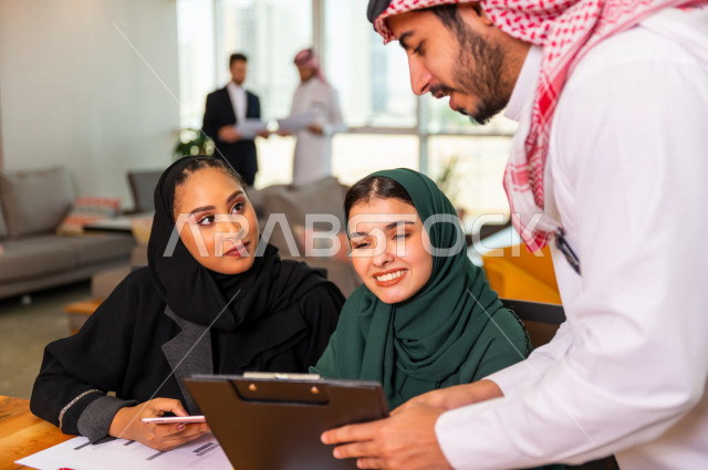 Two Saudi women businessmen in the Gulf in the meeting room inside the ...