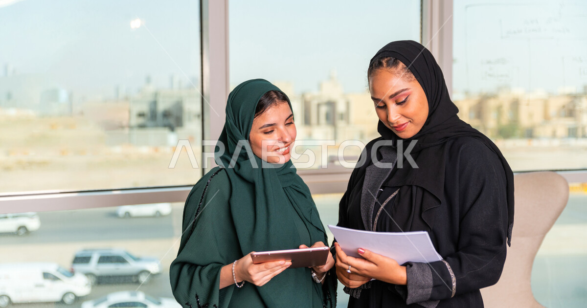 Two Saudi Gulf businesswomen in a business meeting inside the company's ...
