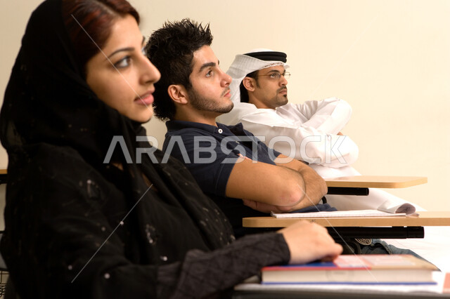 Two students sitting with folded hands, a group of Emirati Gulf Arab ...