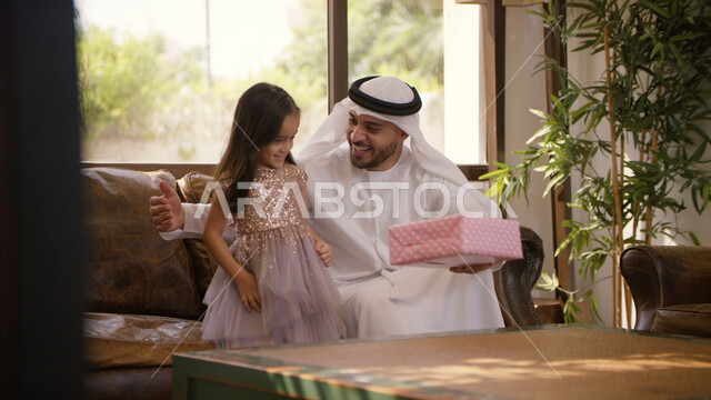 A close-up of an Arab, Gulf, Emirati father wearing an Emirati kandora ...