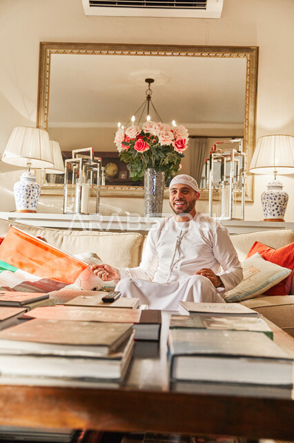 Excitement in watching the football match, an Emirati Arab man wearing ...