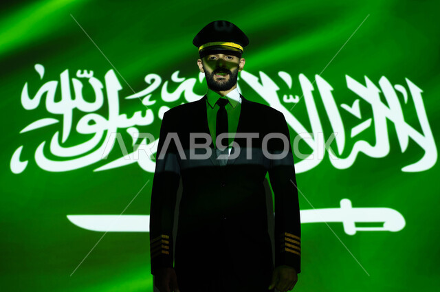 The reflection of the light of the flag on the face of a smiling Saudi ...
