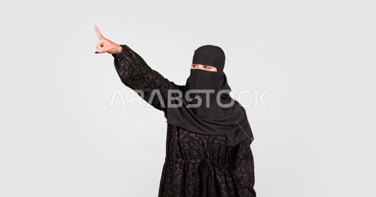 Portrait of a veiled Saudi Arabian Gulf woman, wearing a black abaya ...