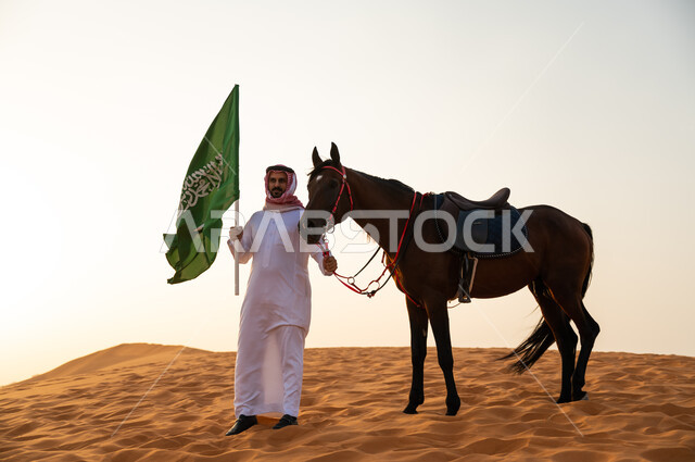 Raising the flag of Saudi Arabia in the desert nature, celebrating with ...