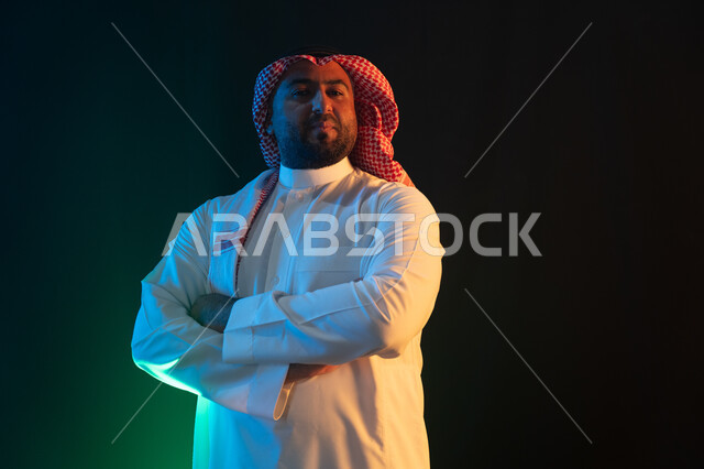 Looking at the camera, a prominent Saudi personality, standing with ...