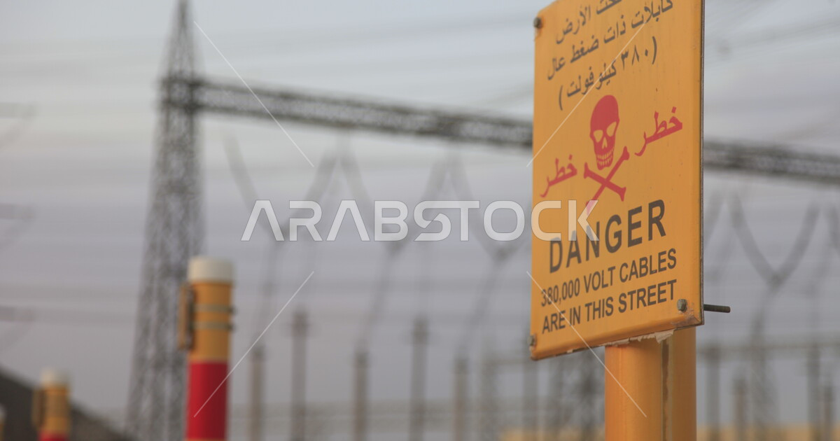 A close-up image of a yellow warning sign in front of the power station ...