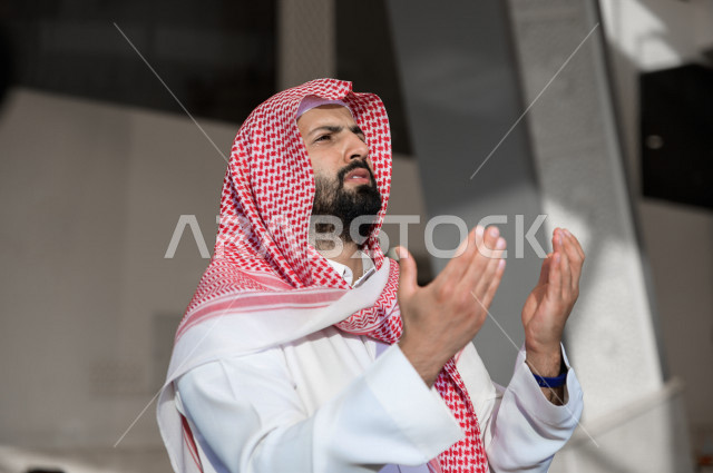 A Saudi Muslim man inside the mosque, raises his hands up and prays to ...