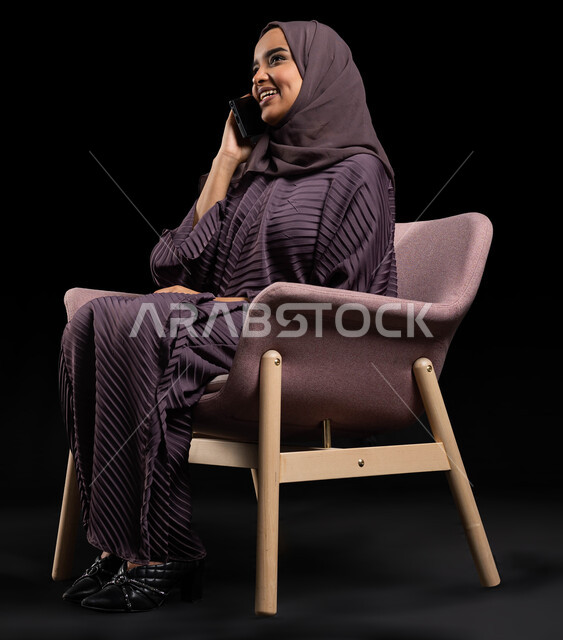 Making phone calls, portrait of a veiled Saudi Arabian Gulf woman ...