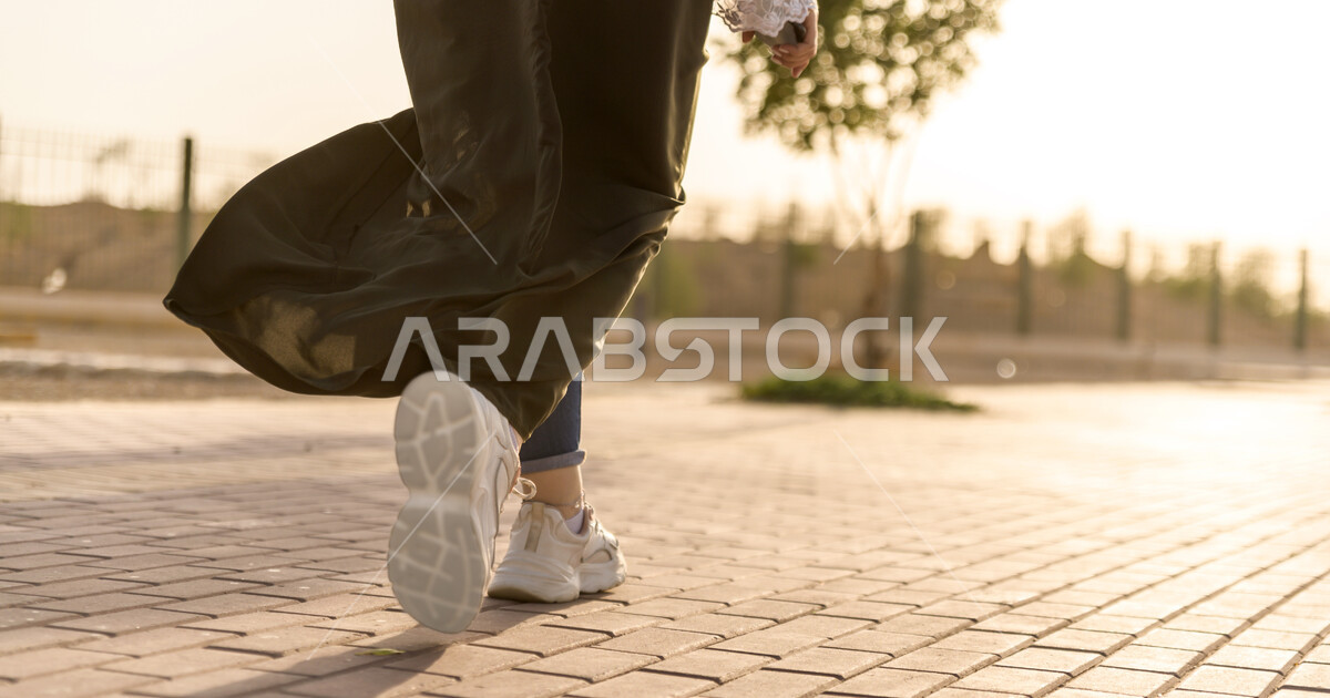 A young Saudi Arabian girl practicing outdoor morning sports, walking ...