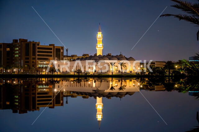 The reflection of the image of the bright Al -Jafali Mosque at night on ...