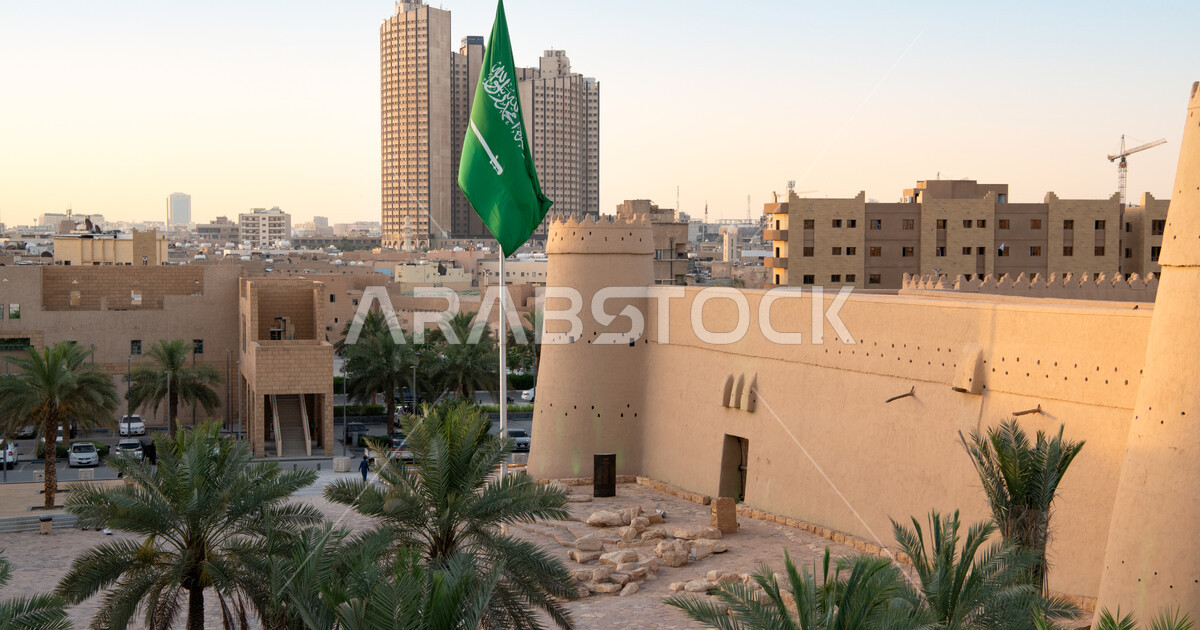The Saudi national flag flagpole flying in the sky, the historic Masmak ...