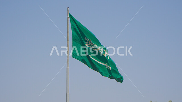 The Saudi flag flying in the sky of the Kingdom, a close-up of the ...