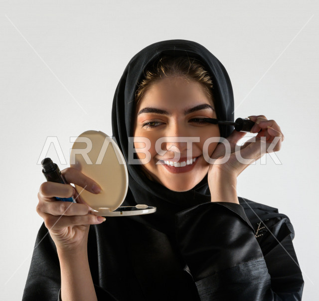 Portrait of a happy Saudi Arabian Gulf woman, who uses a set of ...