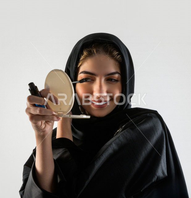 Portrait of a happy Saudi Arabian Gulf woman, who uses a set of ...