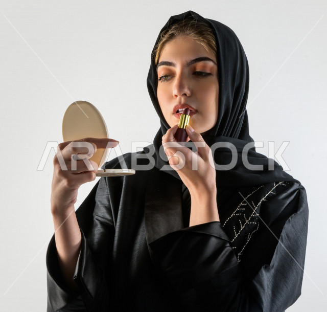 Portrait of a happy Saudi Arabian Gulf woman, who uses a set of ...