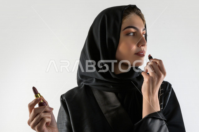 Portrait of a happy Saudi Arabian Gulf woman, who uses a set of ...