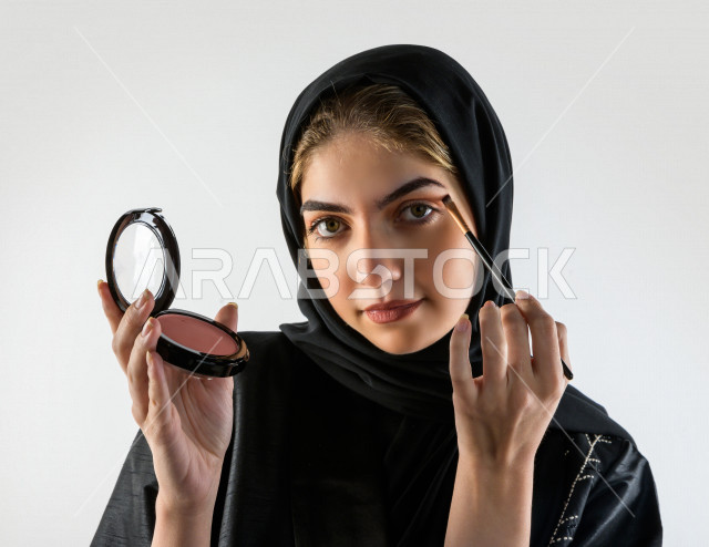 Portrait of a happy Saudi Arabian Gulf woman, who uses a set of ...