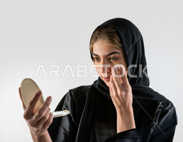Portrait of a happy Saudi Arabian Gulf woman, who uses a set of ...