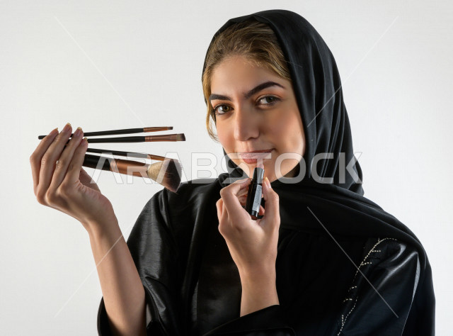Portrait of a happy Saudi Arabian Gulf woman, who uses a set of ...