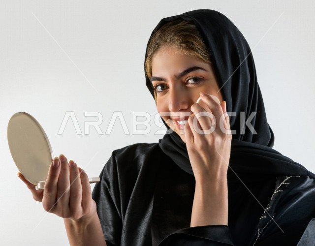 Portrait of a happy Saudi Arabian Gulf woman, who uses a set of ...
