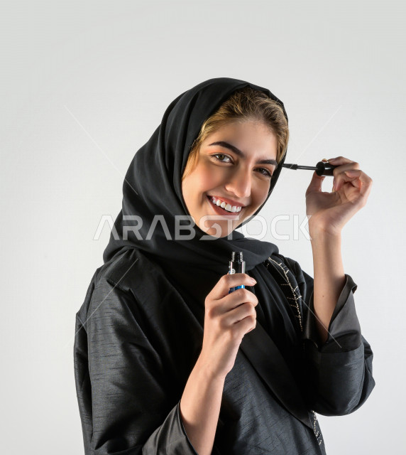 Portrait of a happy Saudi Arabian Gulf woman, who uses a set of ...