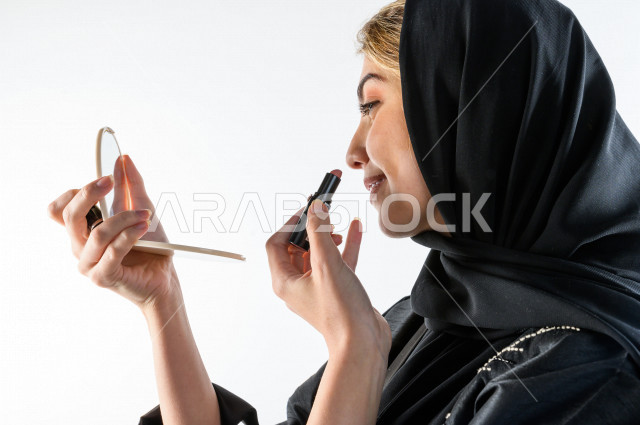 Portrait of a happy Saudi Arabian Gulf woman, who uses a set of ...