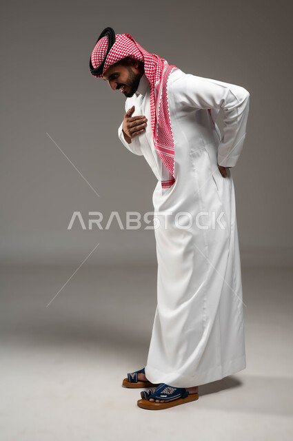 Spine and back pain, portrait from the side of a Saudi Arabian Gulf man ...