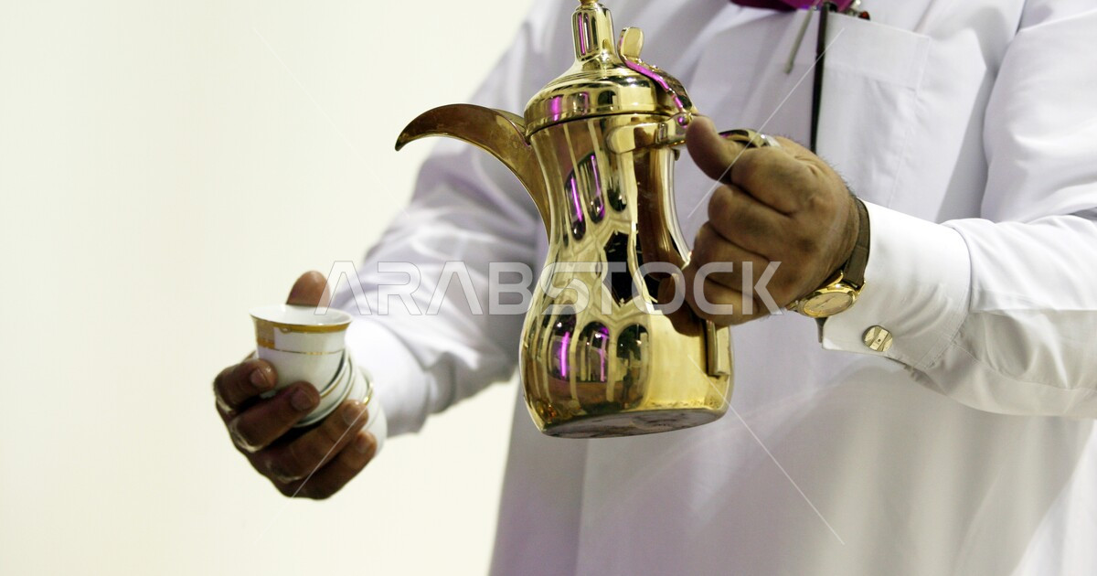 Portrait of a Saudi Gulf Arab man wearing traditional clothing serving ...