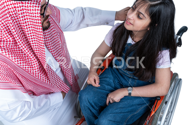 Portrait of a Saudi Arabian girl who is wheelchair-bound with her ...