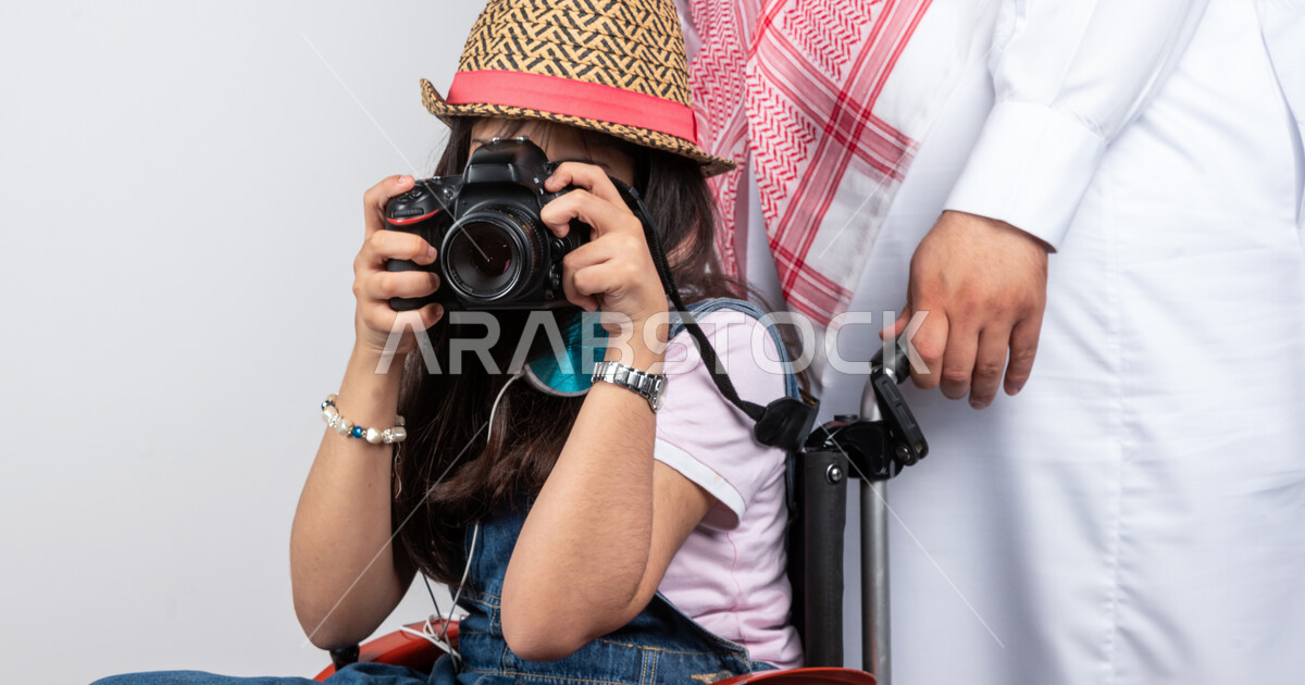Portrait of a Saudi Arabian girl in a wheelchair with her father, ready ...