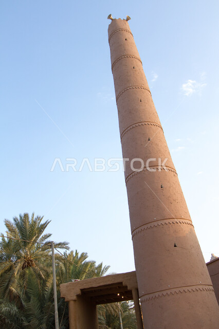 The minaret of a mosque in Buraidah in Al-Qassim, palm plantations in ...