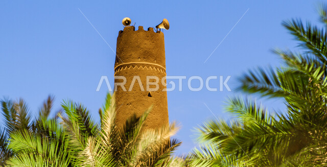 The minaret of a mosque in Buraidah in Al-Qassim, palm plantations in ...