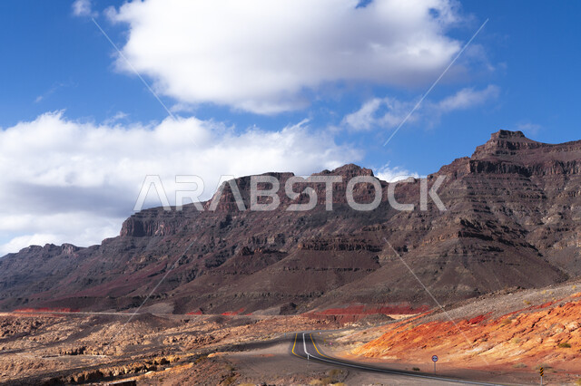A bumpy, winding asphalt road in the middle of the rocky mountains in ...