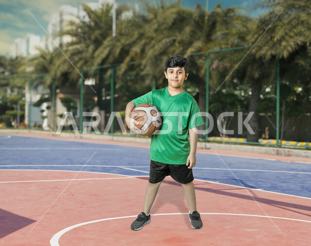 Hobby of playing with ball, Saudi Arabian Gulf boy wearing sports ...