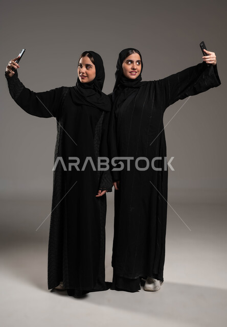 Enjoying taking souvenir photos via mobile phone, a portrait of twin ...