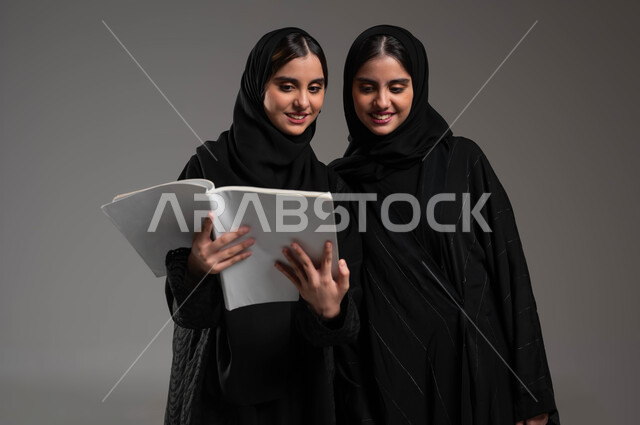 Spending time reading and educating, a close-up portrait of two veiled ...