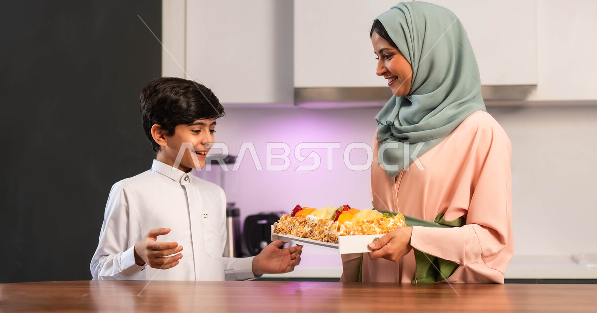 A boy excited to taste sweets, a Saudi Arabian Gulf mother standing ...