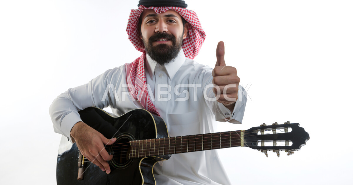 Portrait of a young Saudi Arab from the Gulf playing the guitar (a ...