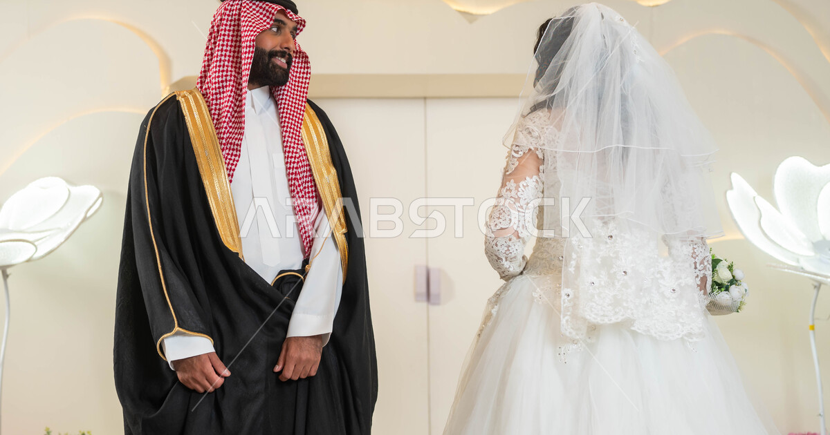 A beautiful Saudi Arabian Gulf bride wearing a white wedding dress, a ...