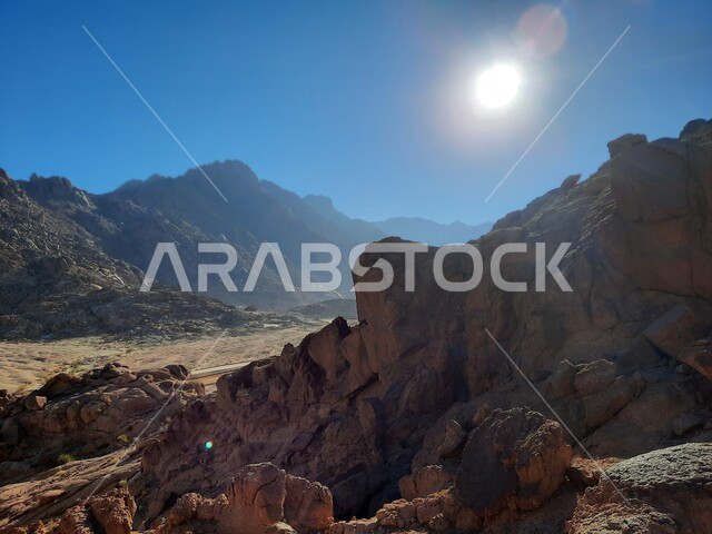 View of the sun disk over the mountain range adjacent to Split Rock in ...