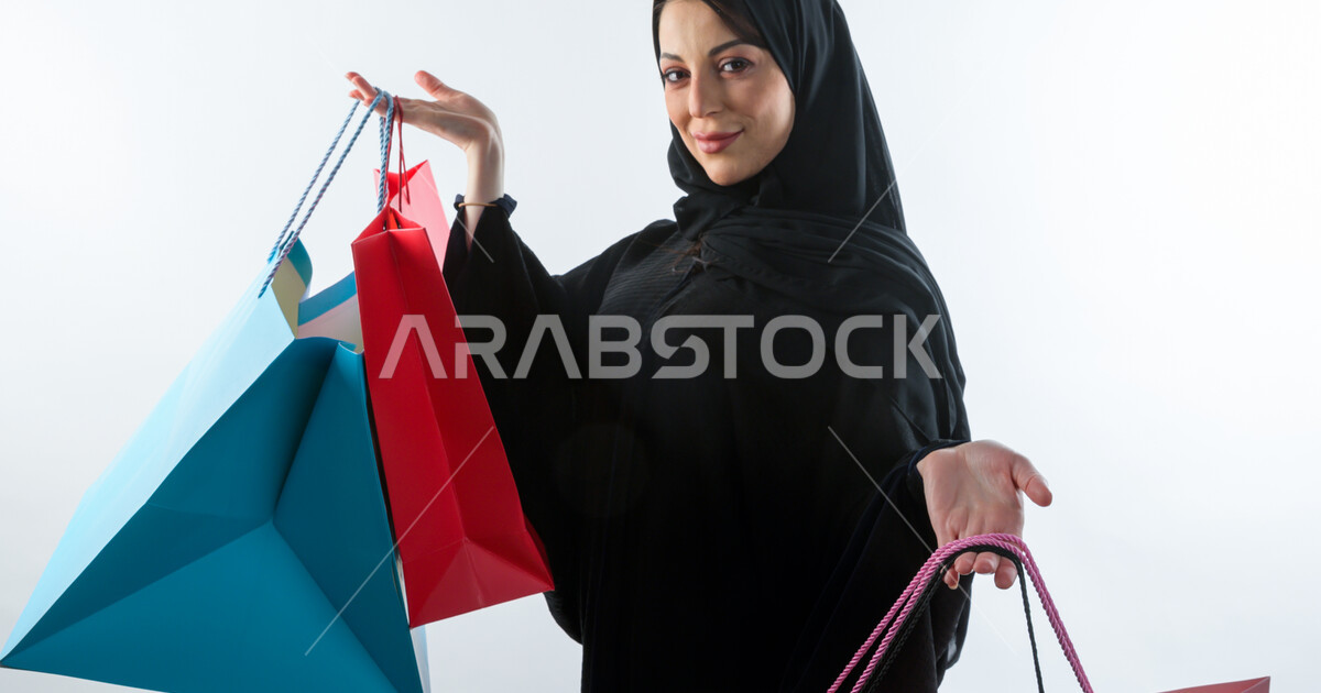 Portrait of a Saudi Arabian Gulf woman carrying shopping bags, buying ...