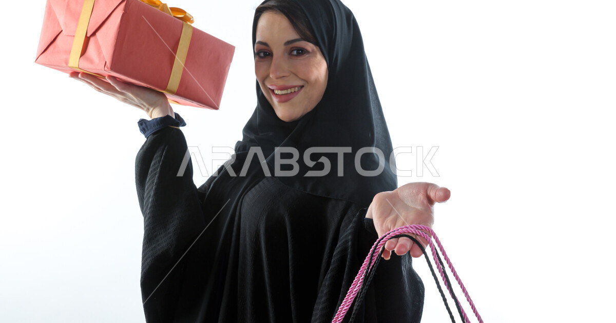 Portrait of a Saudi Arabian Gulf woman carrying shopping bags, buying ...
