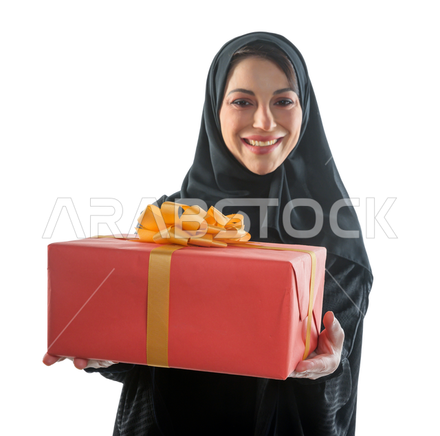 Portrait of a Saudi Arabian Gulf woman carrying a large gift box ...