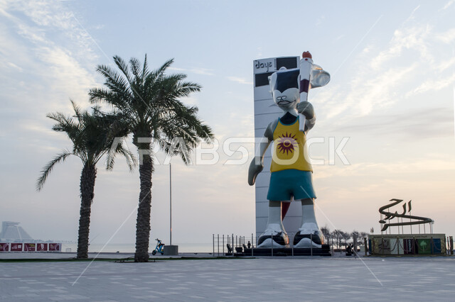 A giant statue of Ori in the Doha Corniche, natural green palm trees ...