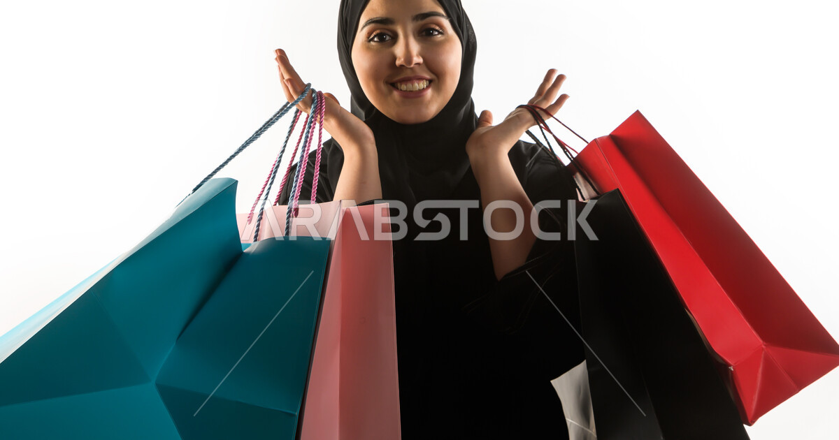 Portrait of a Saudi Arabian Gulf woman carrying shopping bags, buying ...