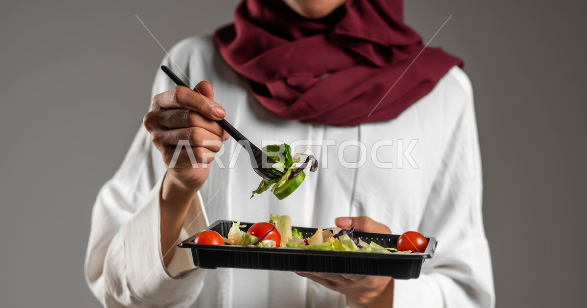 Diet concept, close-up portrait of a Saudi Gulf Arab woman wearing a ...